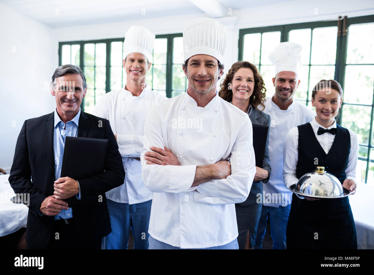 Happy restaurant team standing together in restaurant Stock Photo - Alamy