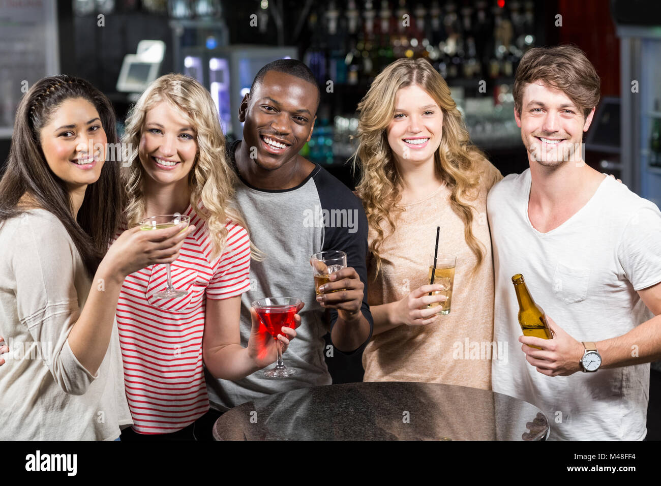 Happy friends toasting with beer and cocktails Stock Photo - Alamy
