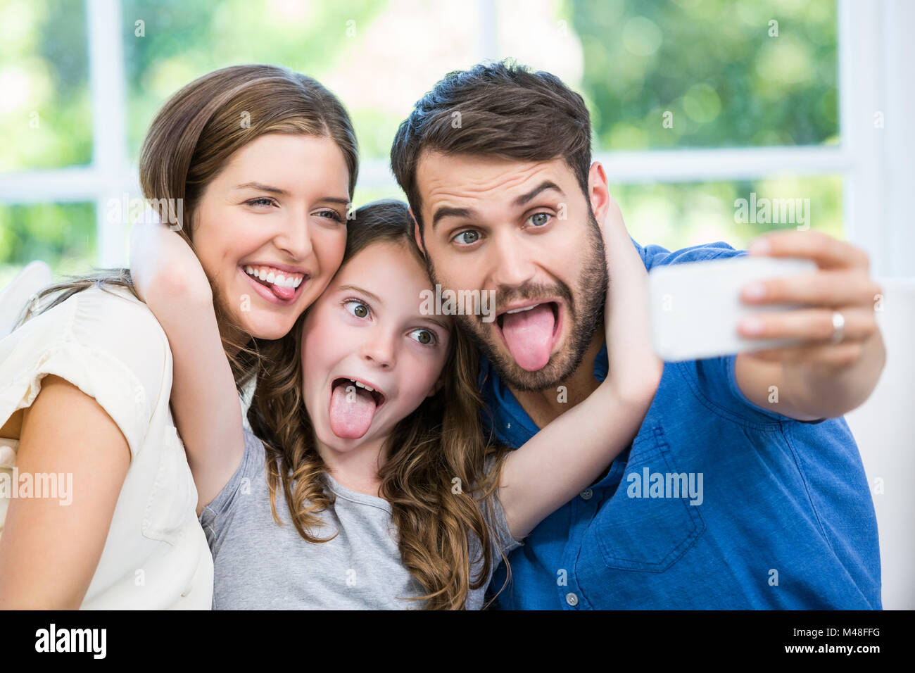 Happy family making faces while clicking selfie Stock Photo - Alamy