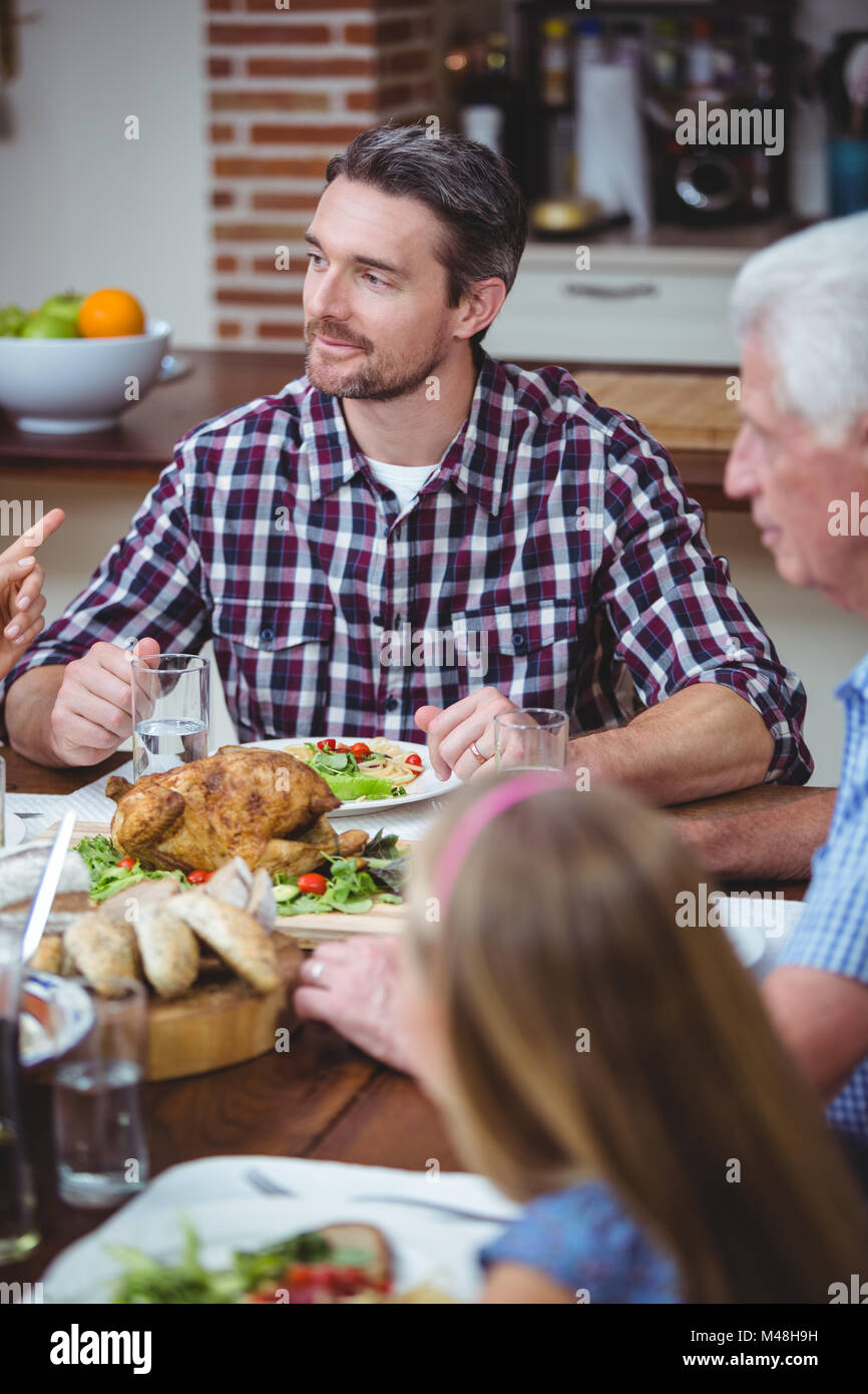 Multi generation family sitting at dining table Stock Photo - Alamy