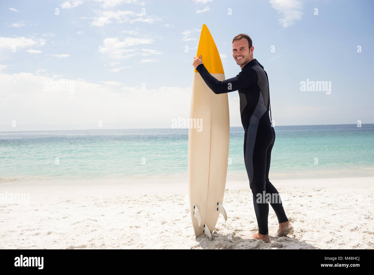 Happy surfer holding a surfboard on the beach Stock Photo - Alamy