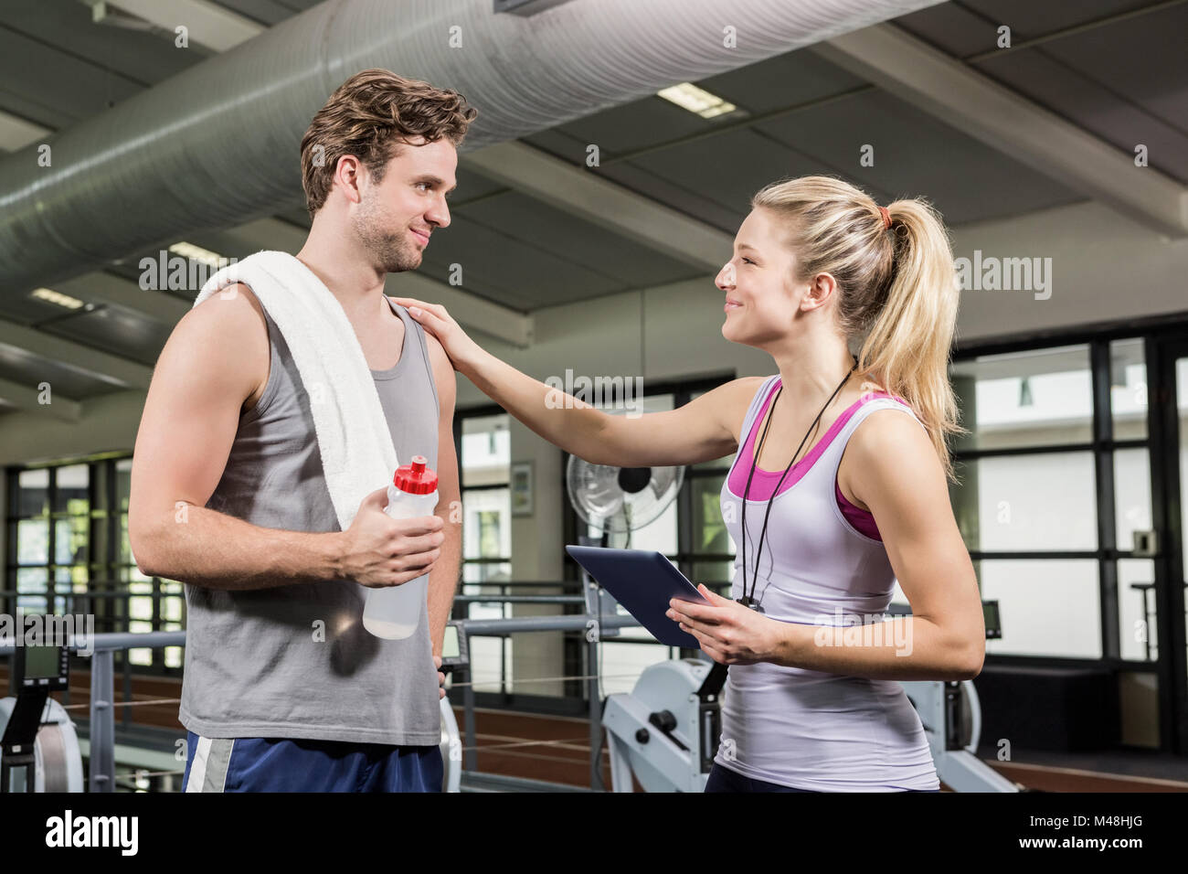 Man interacting with his trainer after a workout Stock Photo - Alamy