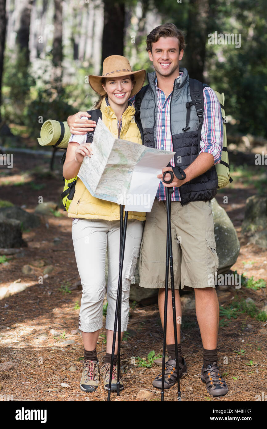 Happy couple holding map and standing on field Stock Photo - Alamy