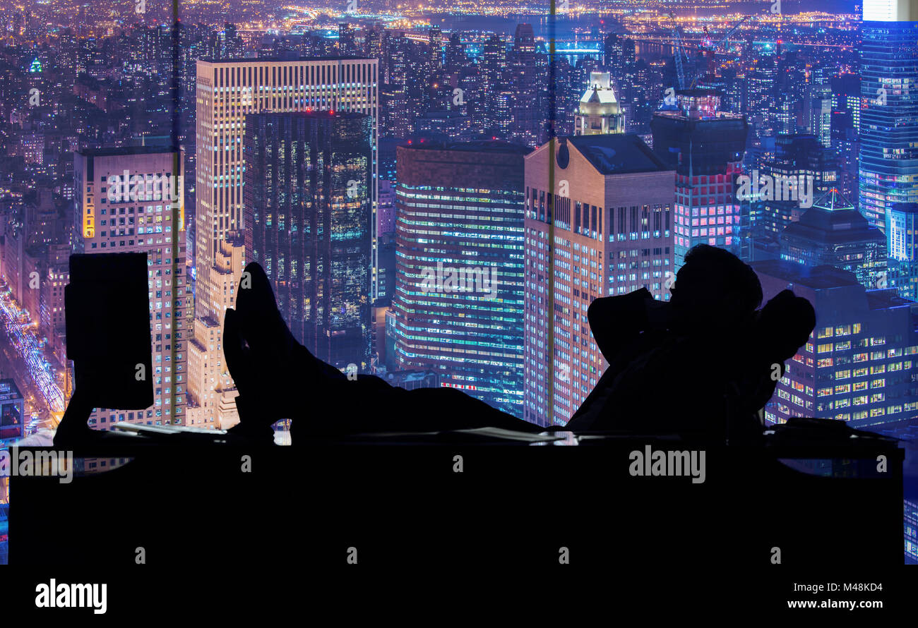 Businessman working in dark room at skyscraper Stock Photo - Alamy