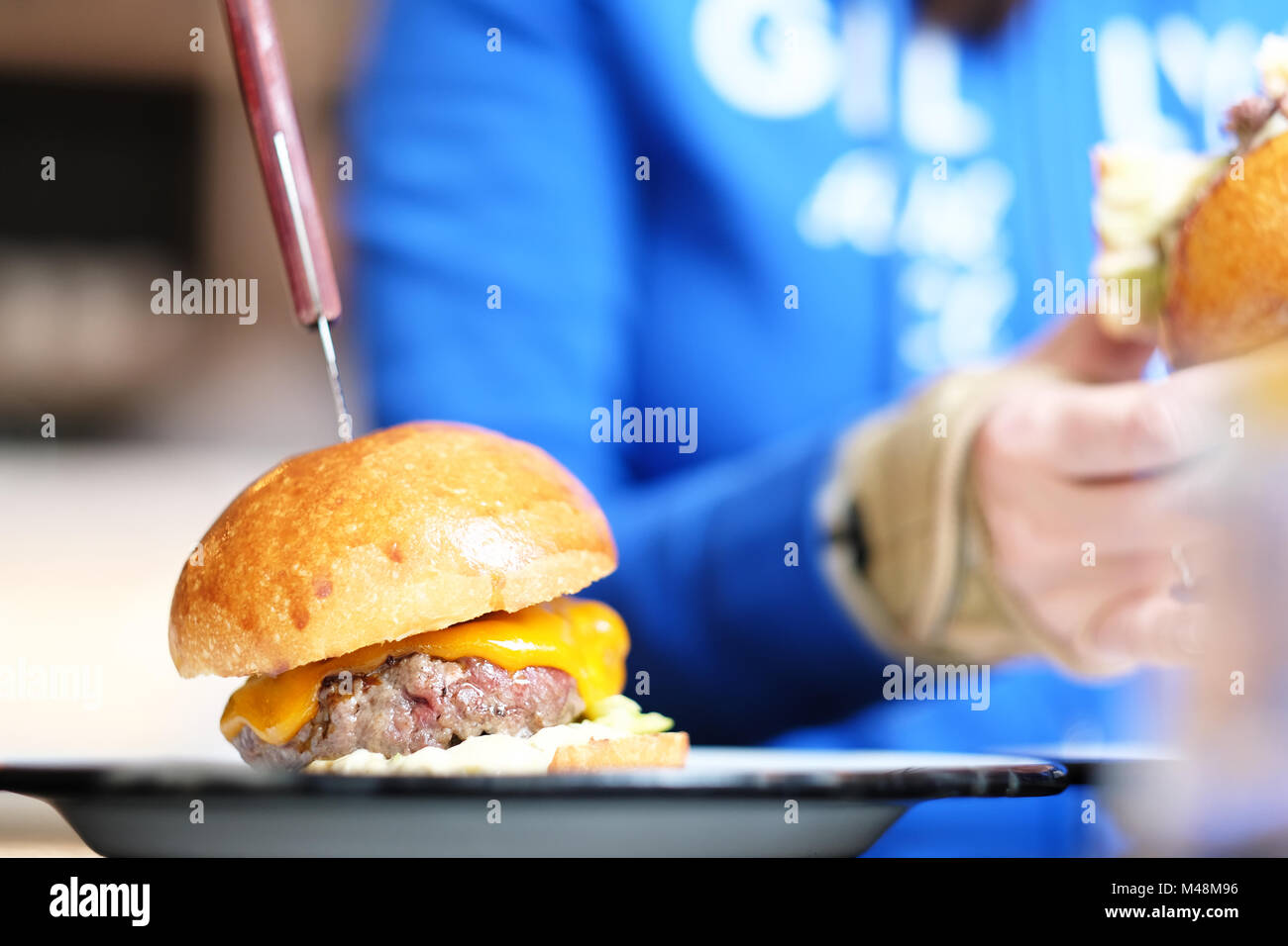 Woman eating cheeseburger Stock Photo - Alamy