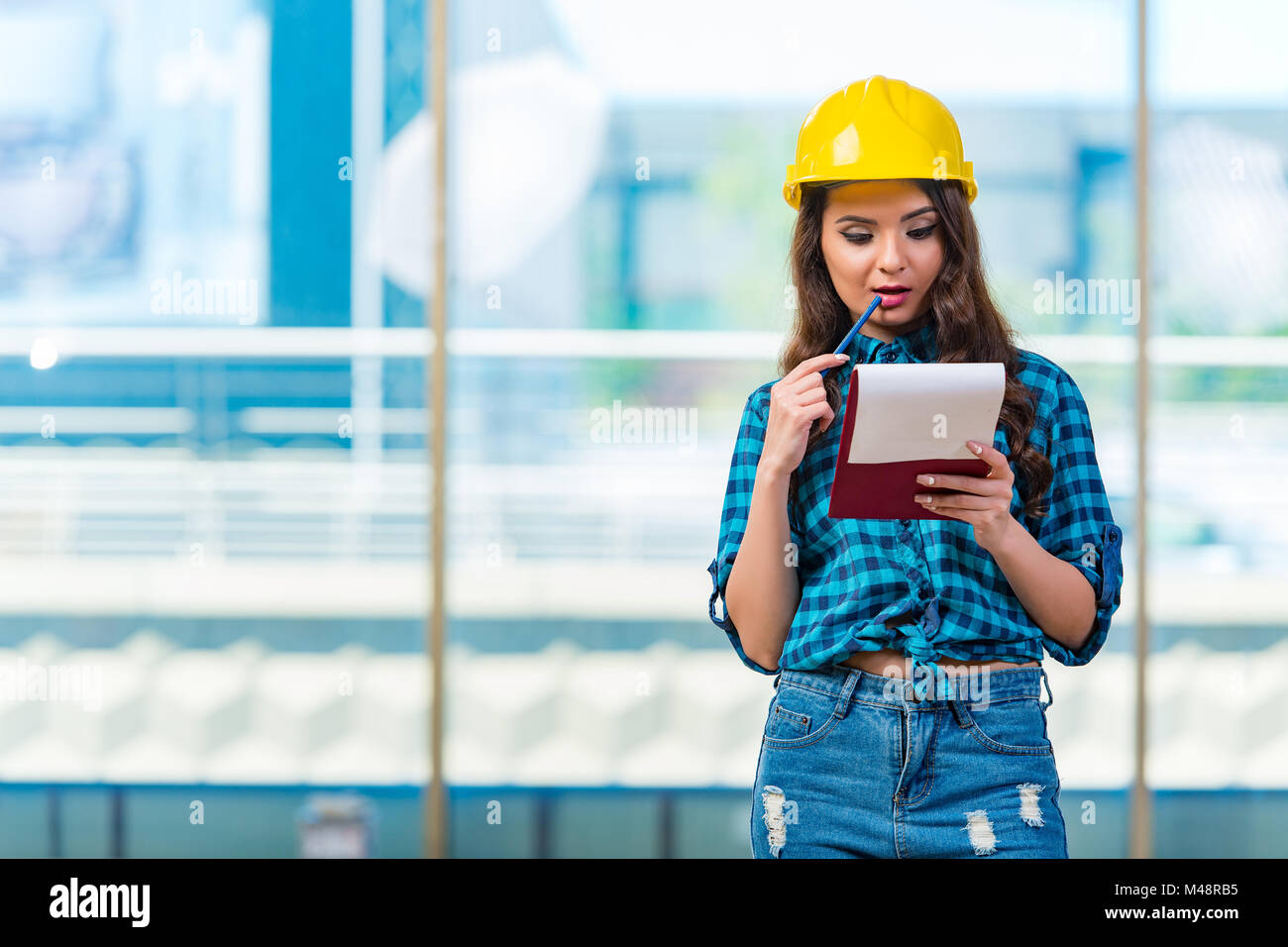 Woman builder taking notes at construction site Stock Photo - Alamy