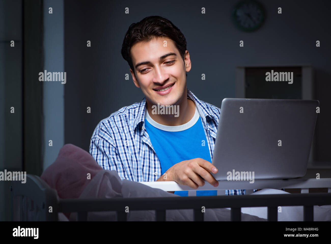 Young student doing homework and looking after newborn baby Stock Photo ...