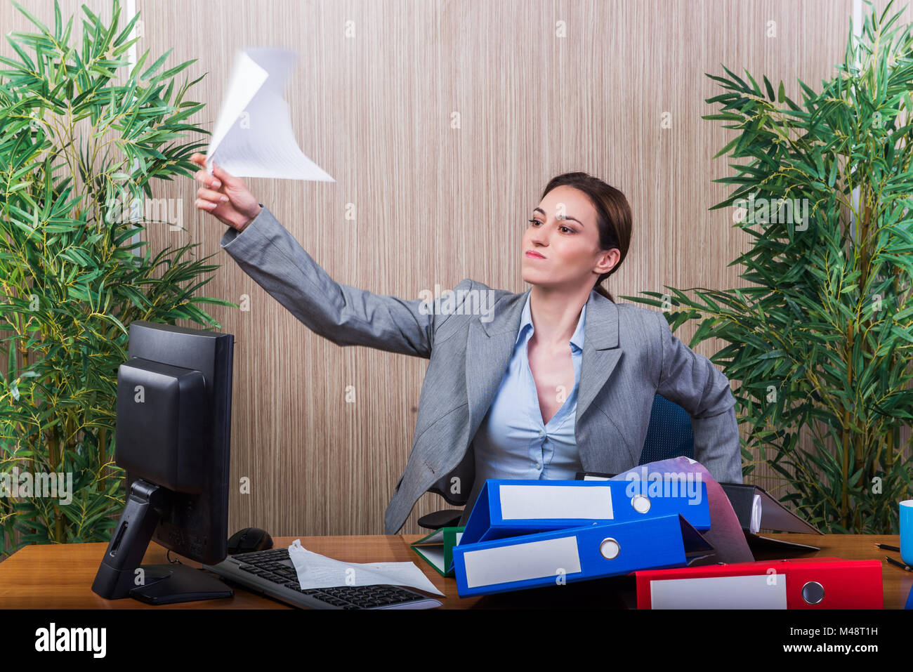 Woman throwing papers in the office under stress Stock Photo - Alamy