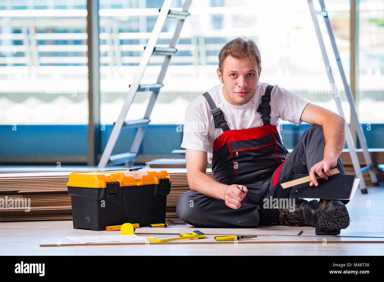 Man laying laminate flooring in construction concept Stock Photo - Alamy