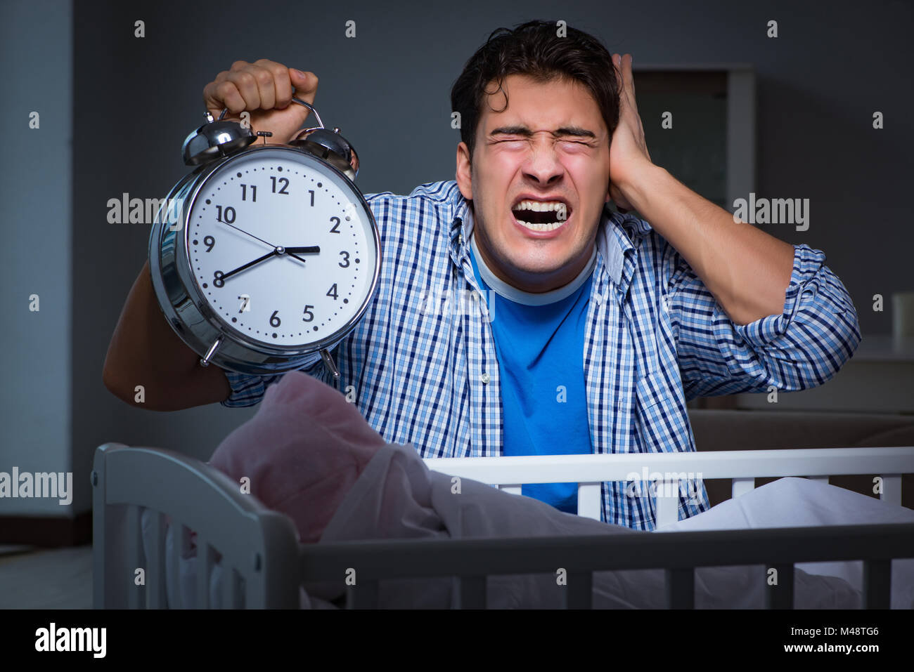 Young father under stress due to baby crying at night Stock Photo - Alamy