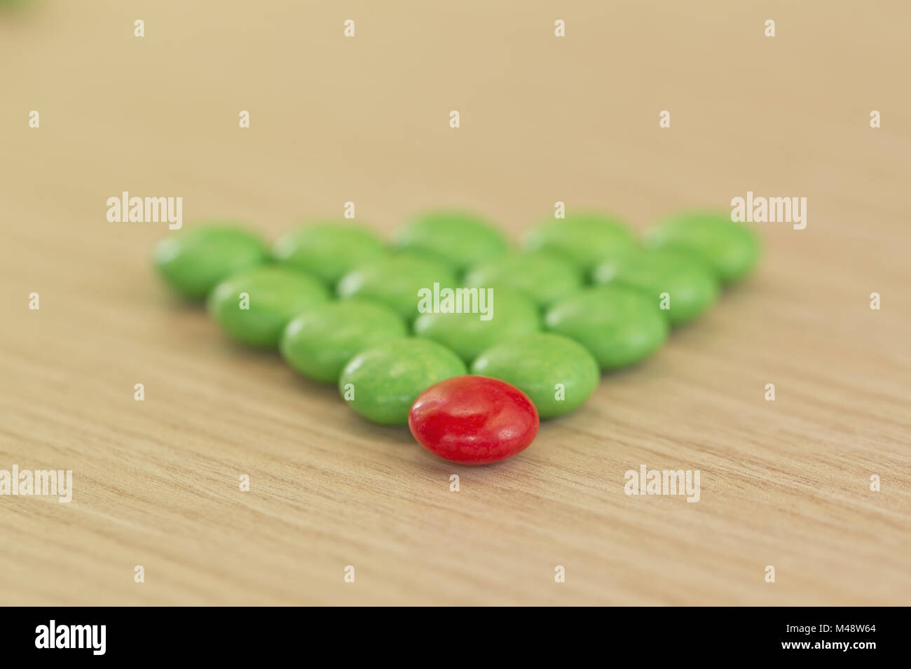 Plenty of green and one red candy Stock Photo - Alamy