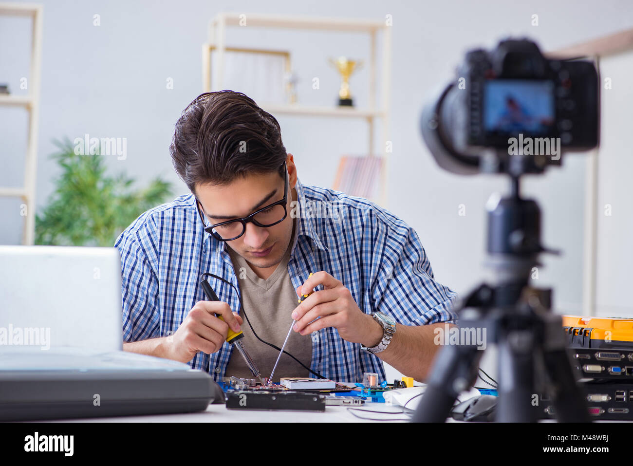 Vlogger recording computer repair on camera for vlog blog Stock Photo - Alamy
