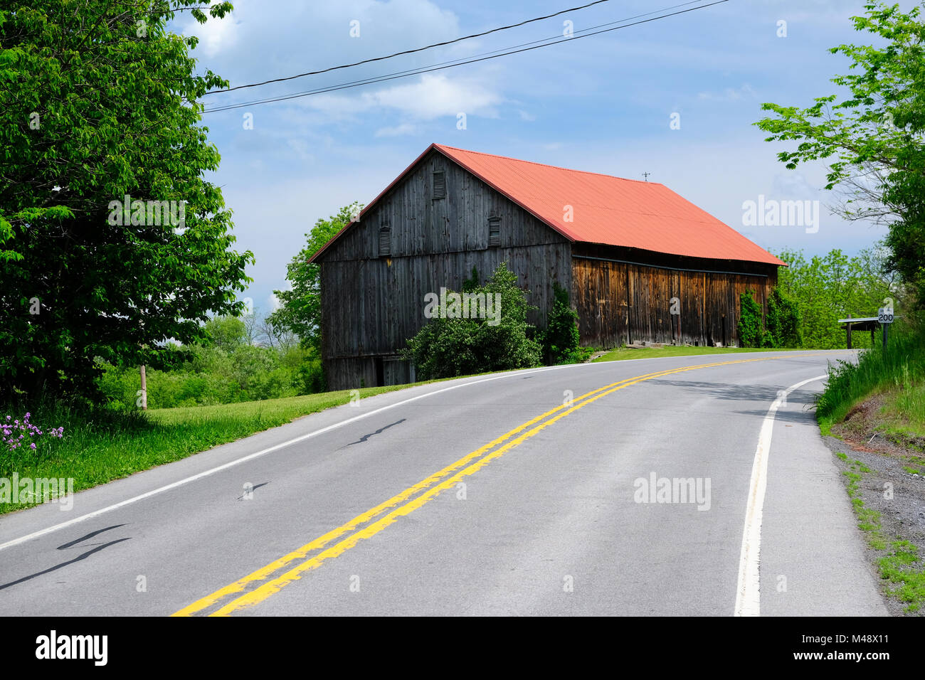Old red roof barn near highway Stock Photo - Alamy