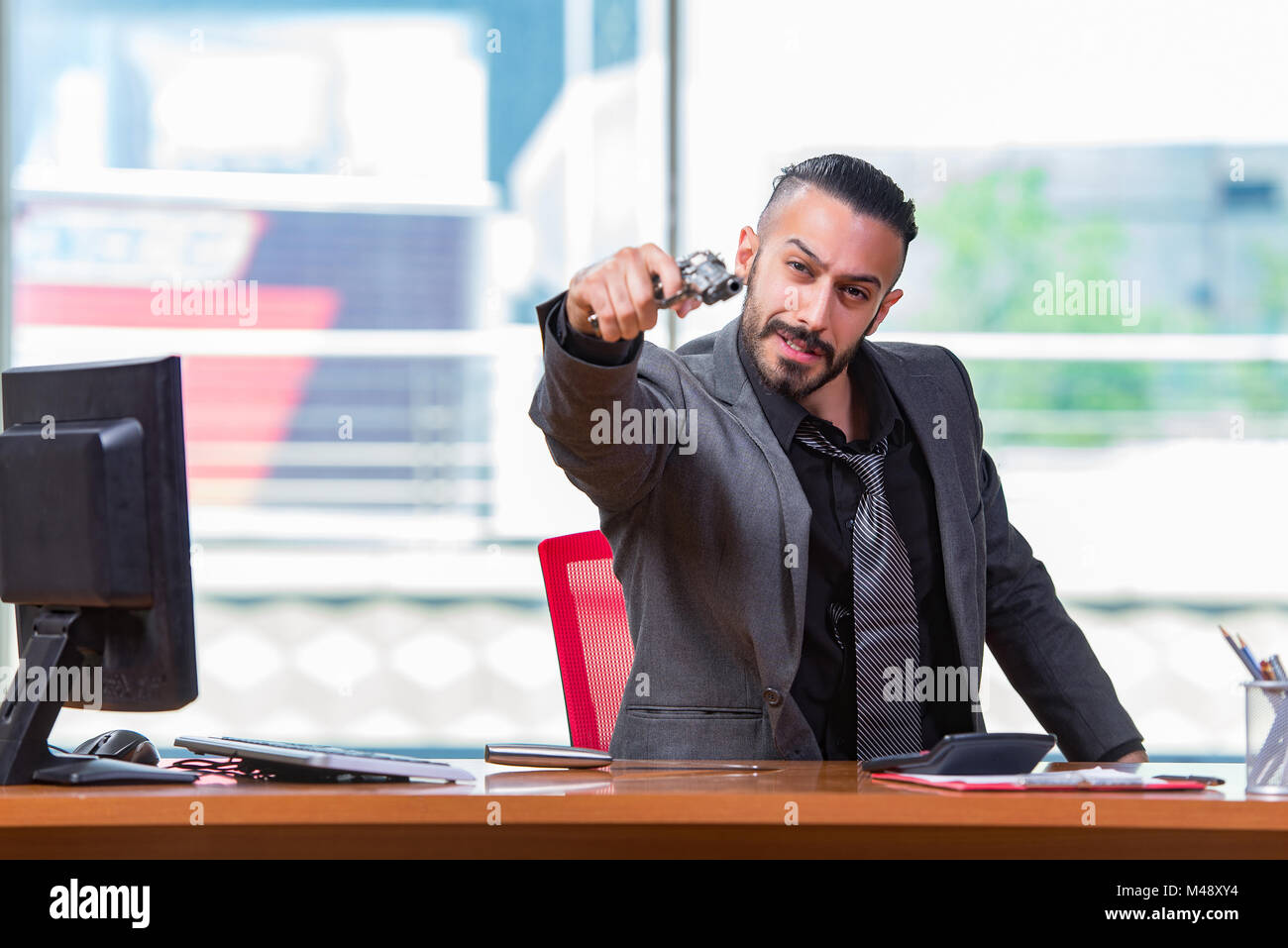 Angry aggressive businessman with gun in the office Stock Photo - Alamy