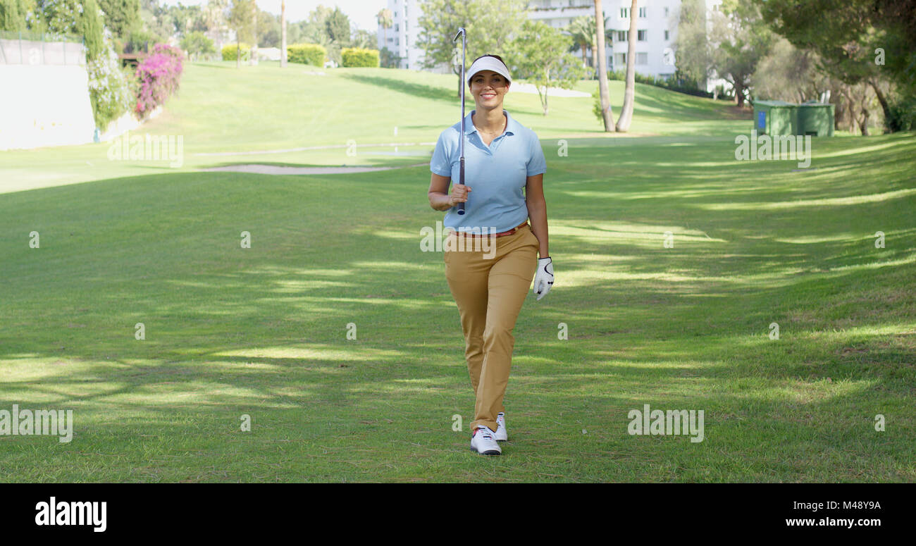 Smiling friendly woman golfer walking on a course Stock Photo - Alamy