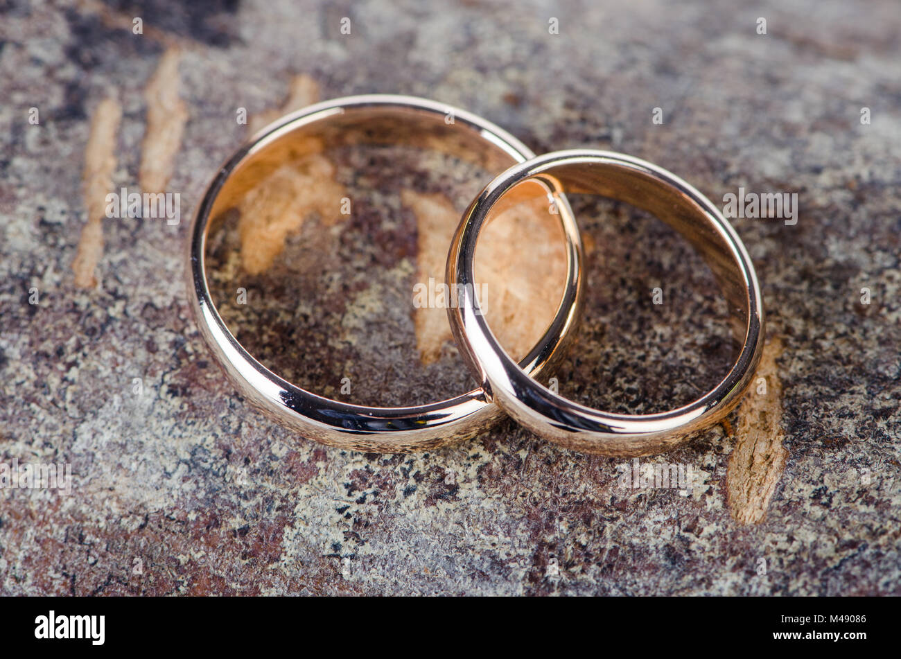 Two gold wedding rings on wooden background Stock Photo - Alamy