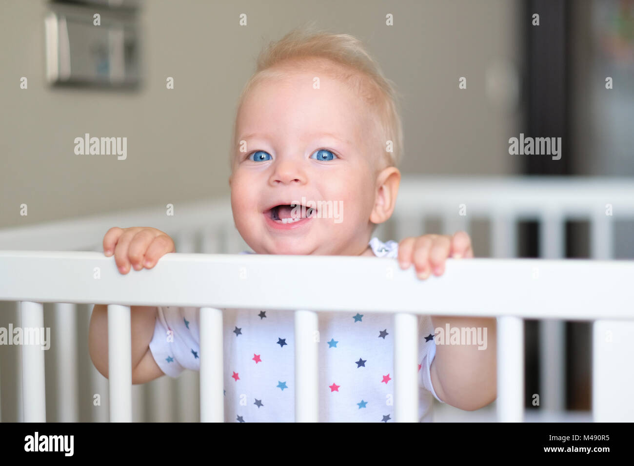 Baby boy standing in crib Stock Photo - Alamy
