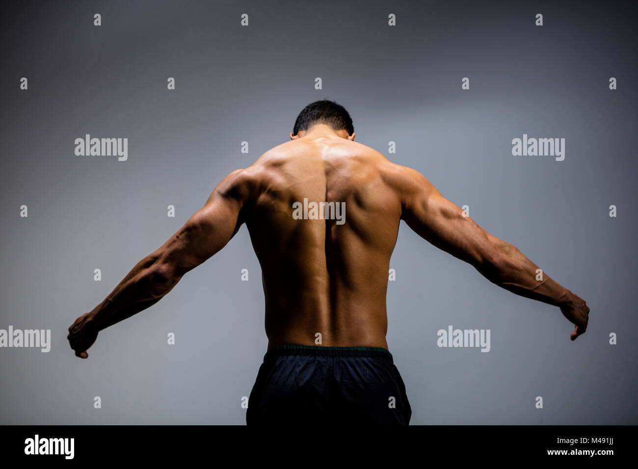 A male fitness model displays his back muscles Stock Photo - Alamy
