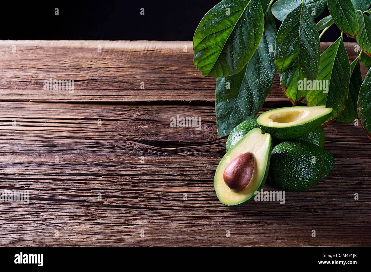 Avocado split in half on old wooden table with free space for your text ...