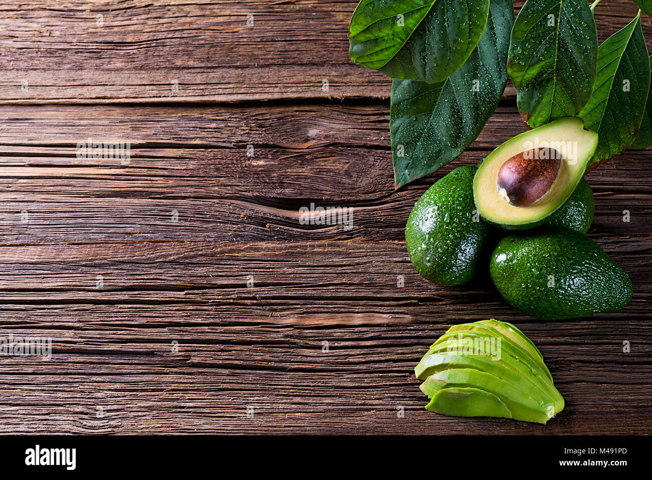 Avocado split in half on old wooden table with free space for your text ...
