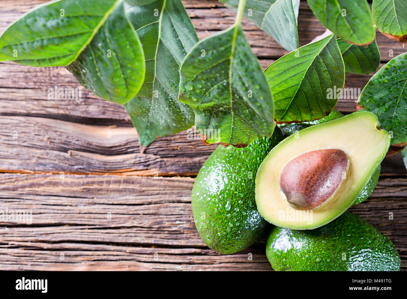 Avocado split in half on old wooden table with free space for your text ...