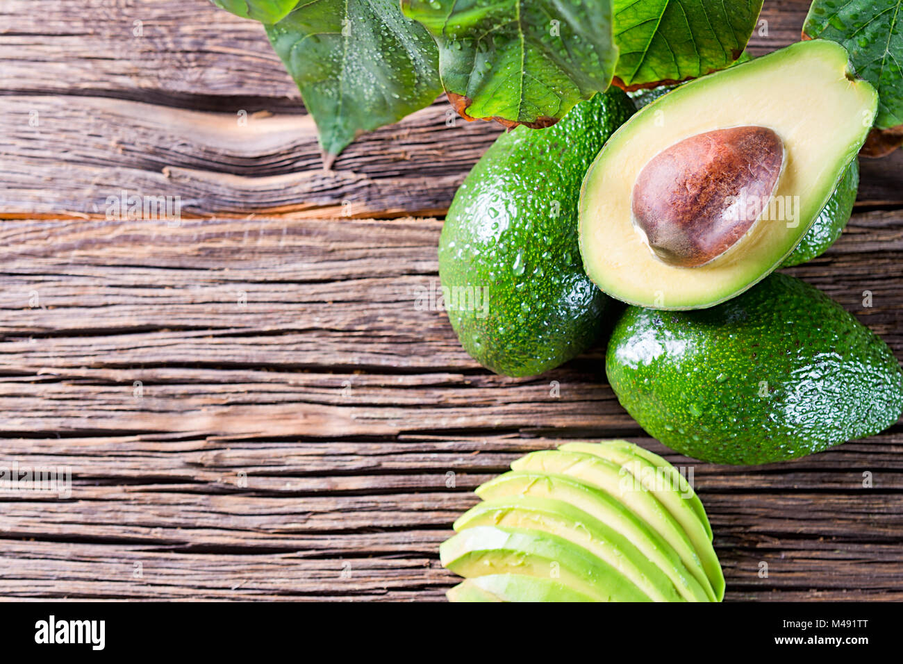 Avocado split in half on old wooden table with free space for your text ...