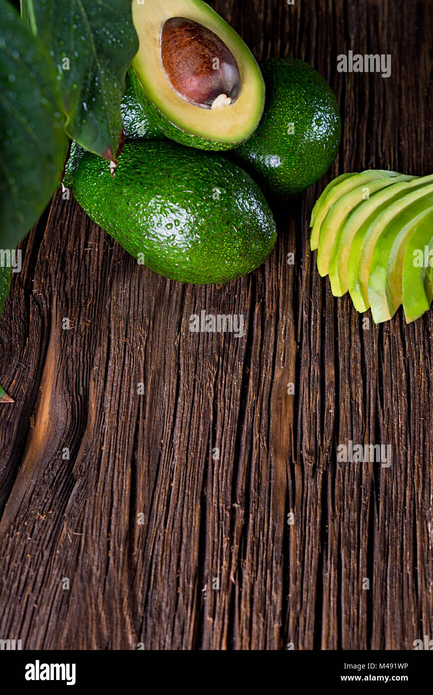 Avocado split in half on old wooden table with free space for your text ...