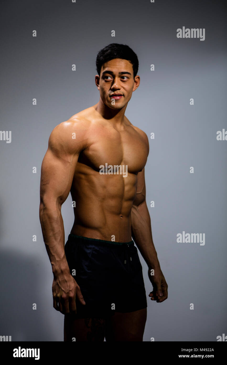 An Asian fitness model poses for the camera with a slight grin. Medium ...