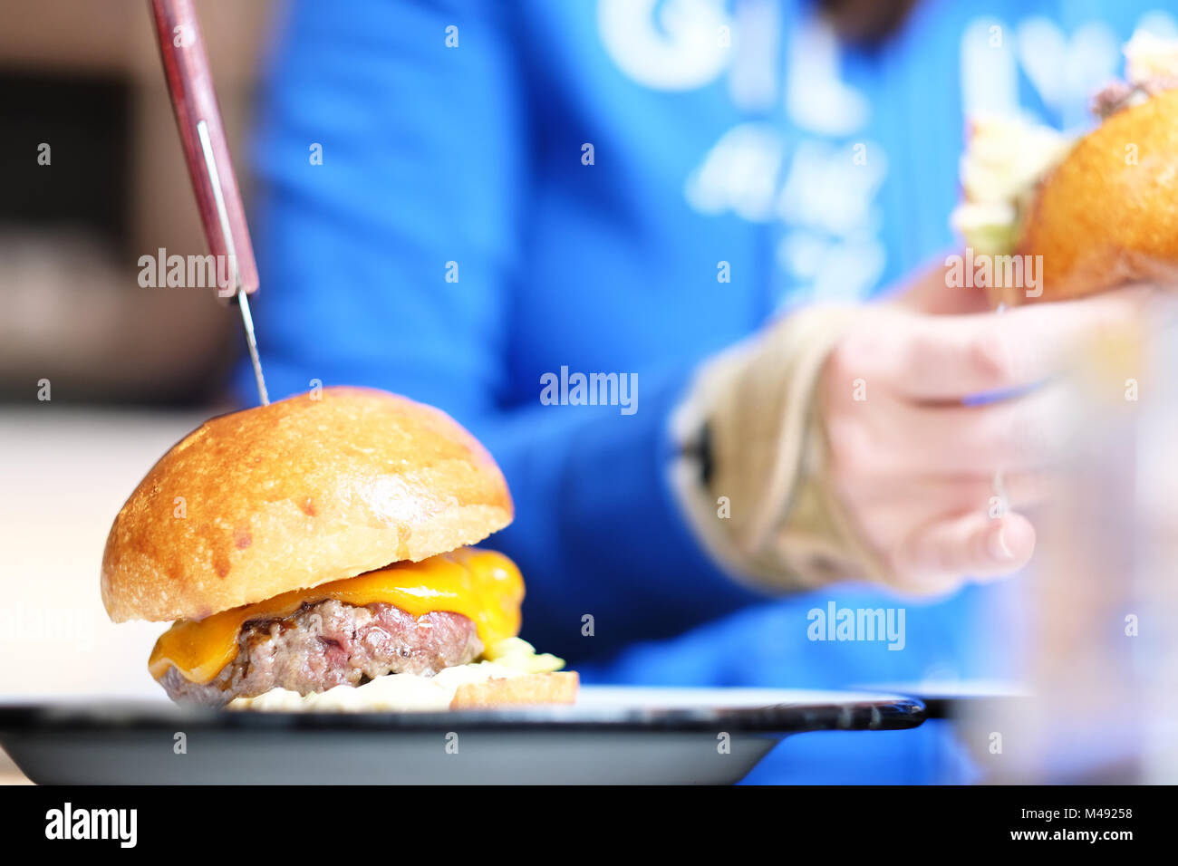 Woman eating cheeseburger Stock Photo - Alamy