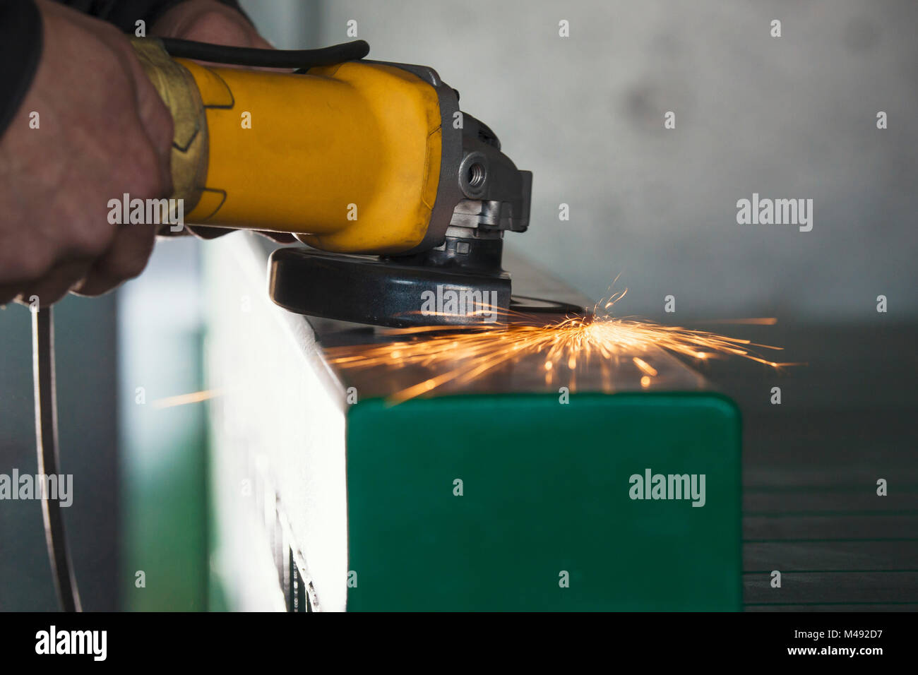 Manual labour - worker grinding the steel mechanism on the plant Stock ...