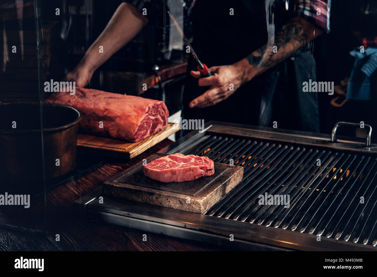 A man cooking beef steak on a grill Stock Photo - Alamy