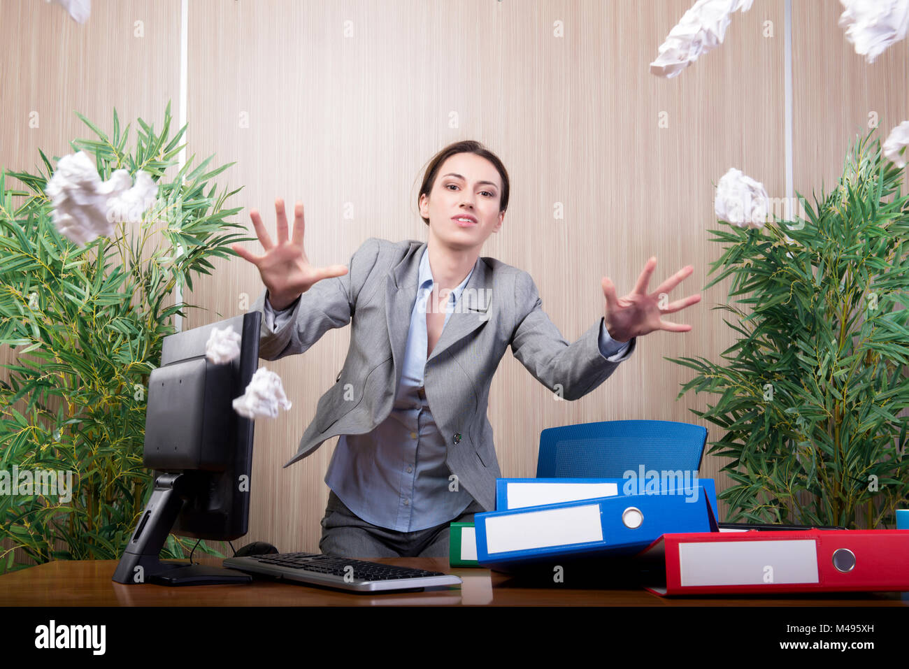 Woman under stress tossing papers in the office Stock Photo - Alamy