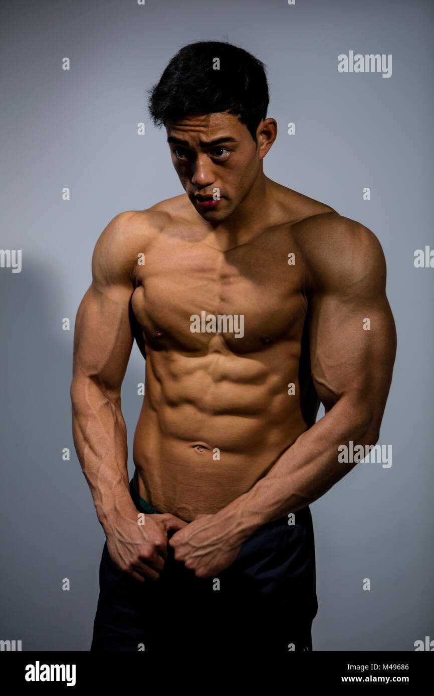 A fitness model flexing his pectoral muscles. Medium shot Stock Photo ...