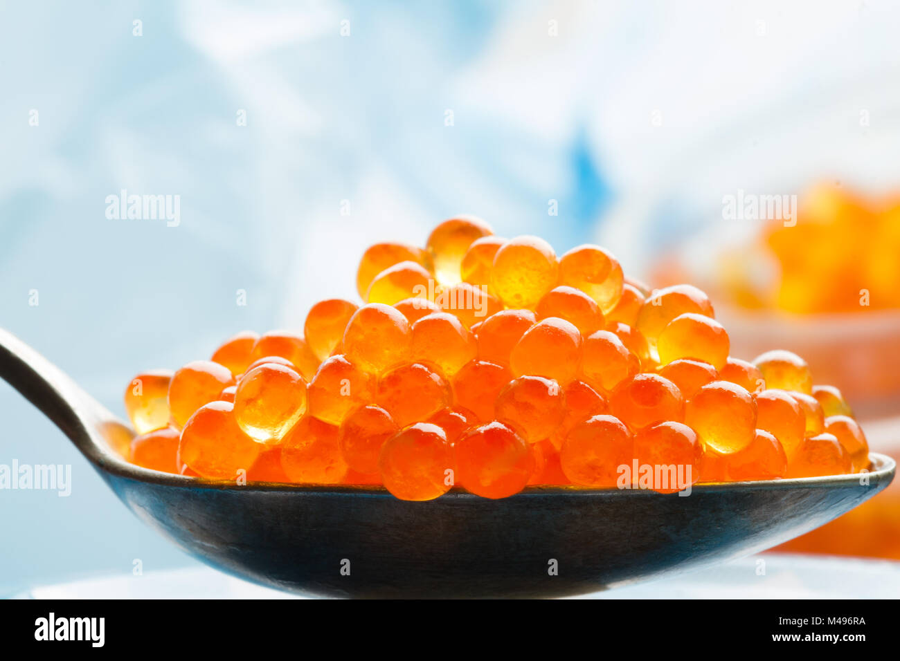 Red caviar on retro spoon macro still life on blue background Stock ...