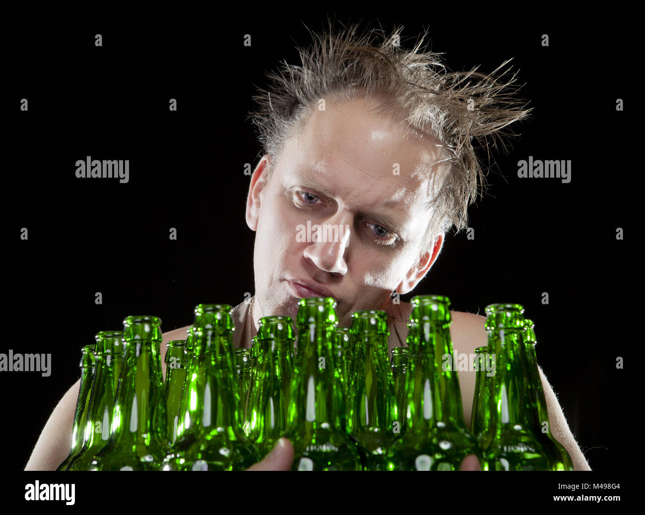 The tipsy man sits with a heap of beer bottles Stock Photo - Alamy