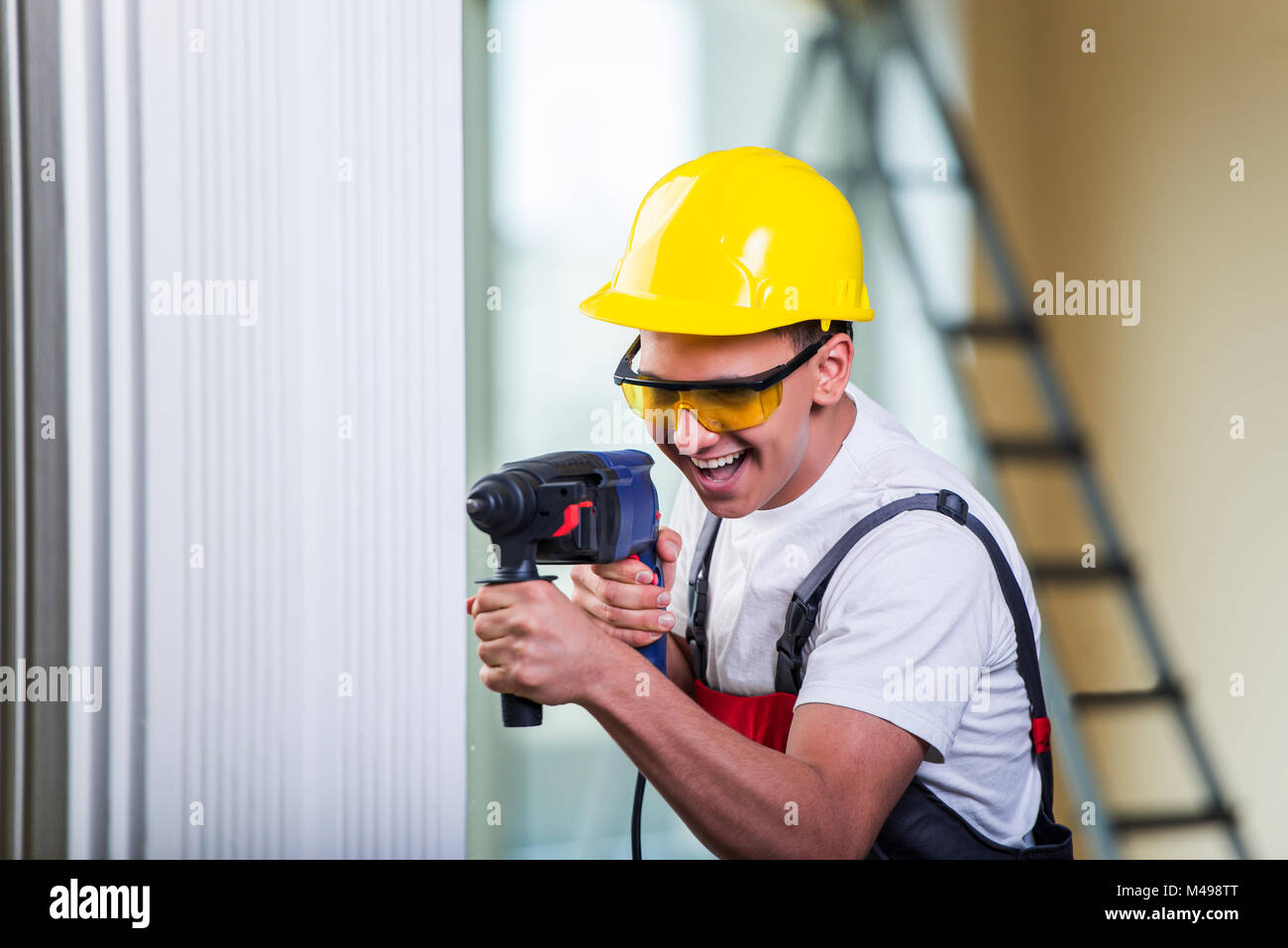 Man drilling the wall with drill perforator Stock Photo - Alamy