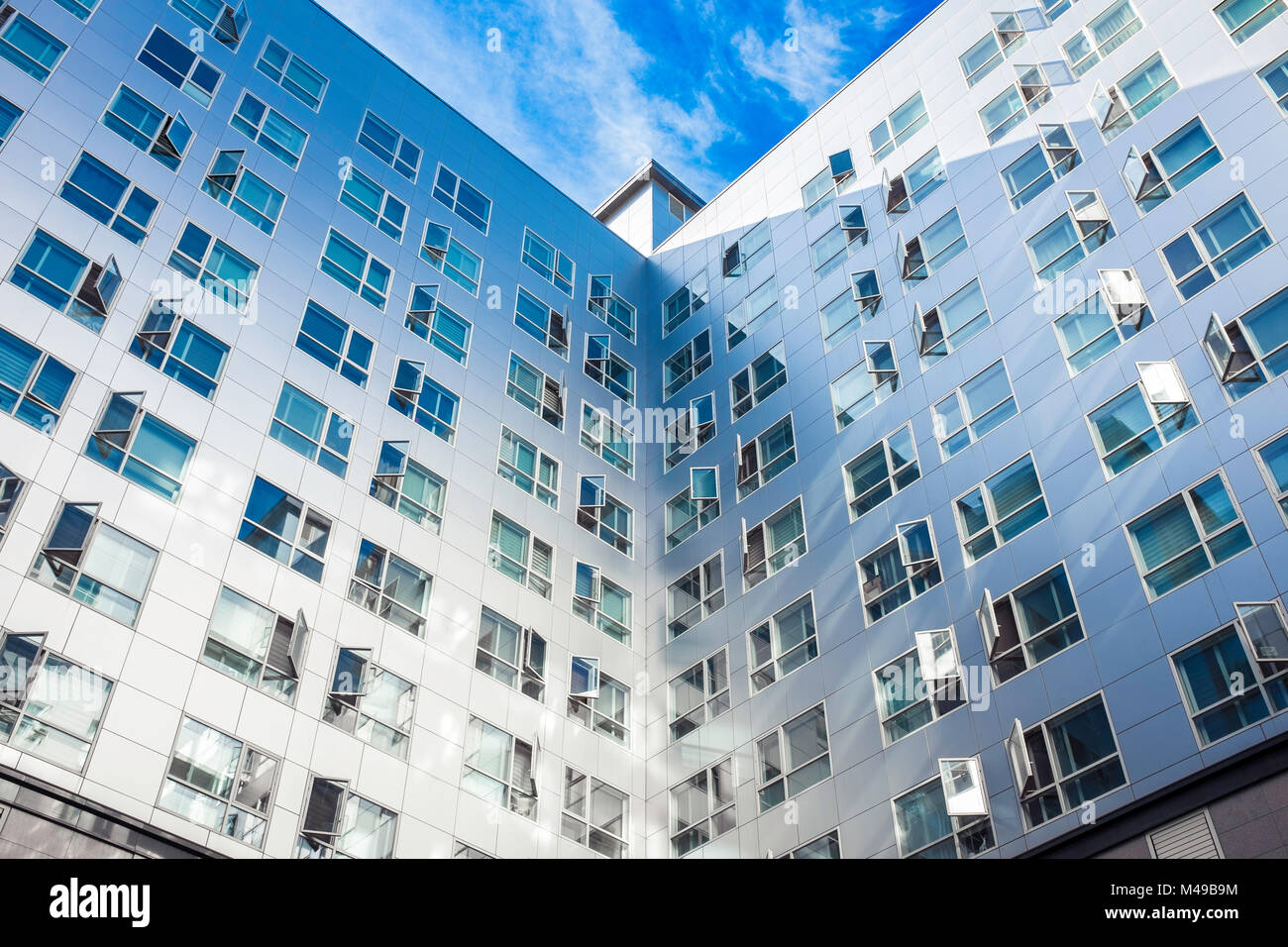 Edgy residence building cast a sky blue tint Stock Photo - Alamy