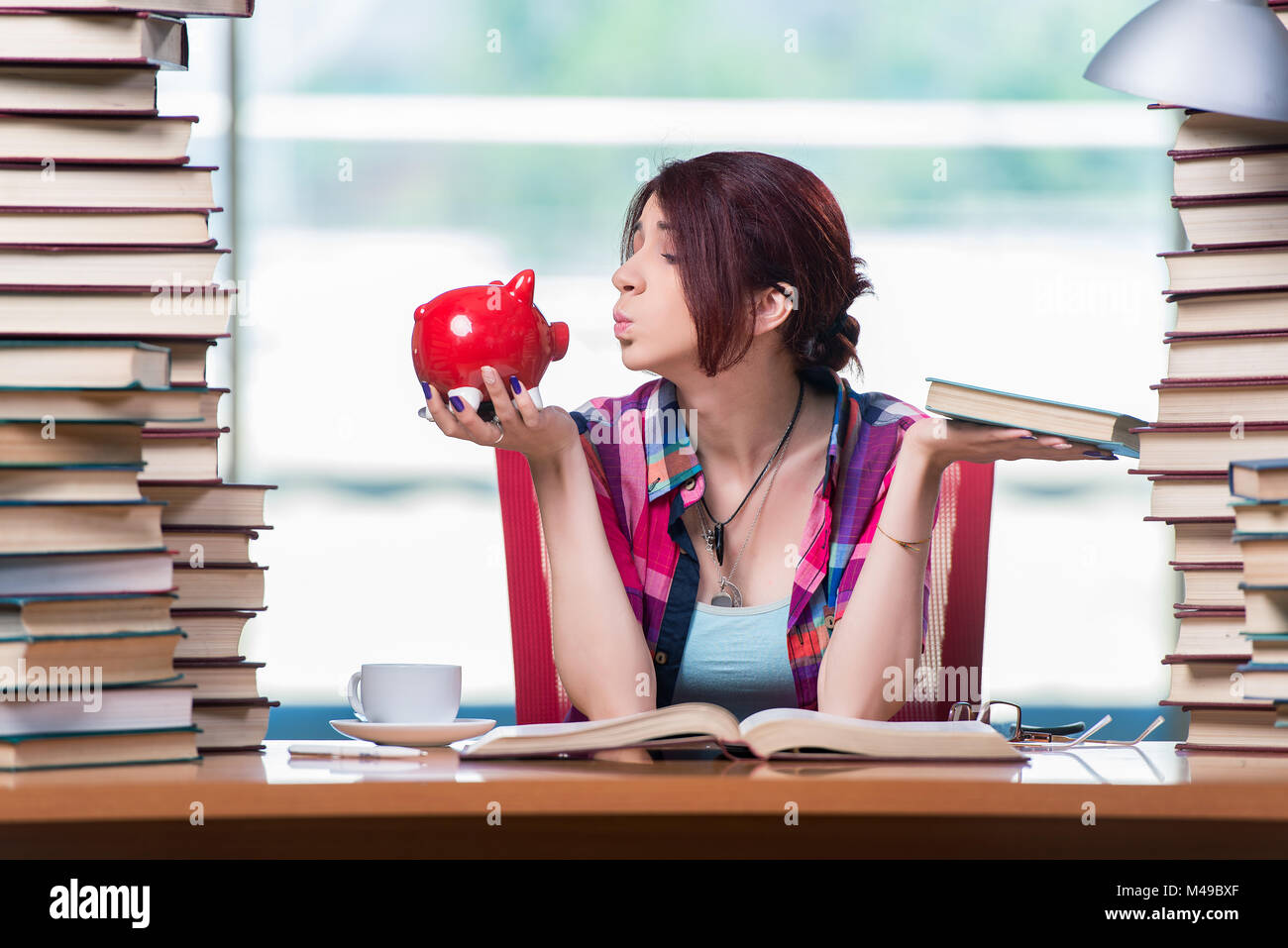 Concept of expensive textbooks with female student Stock Photo - Alamy