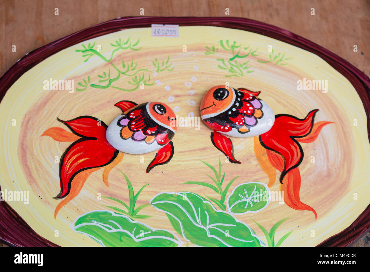 Closeup view of a two fishes. painting on the stone. picture handmade ...