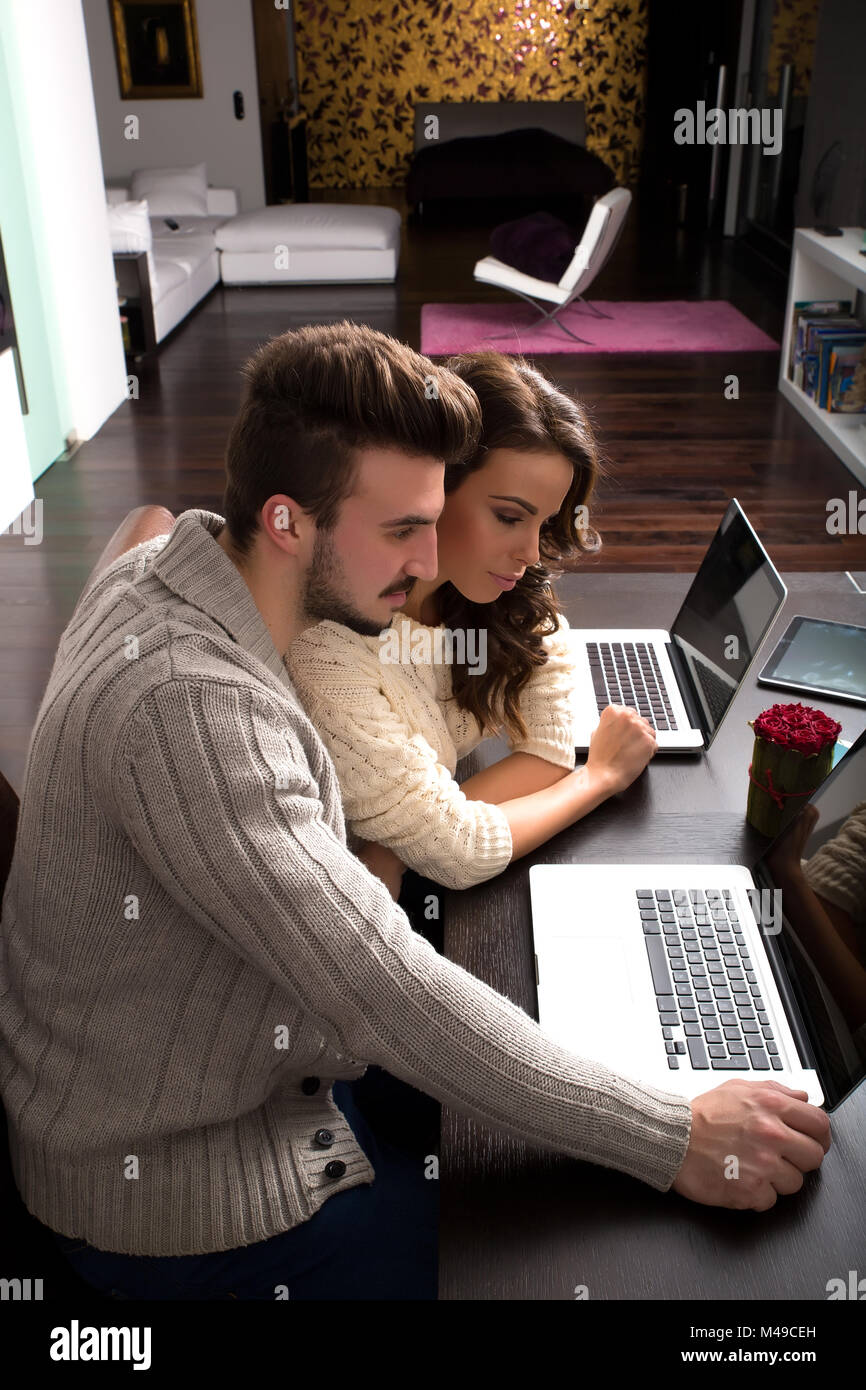 Young couple watching together some content on a laptop computer Stock ...