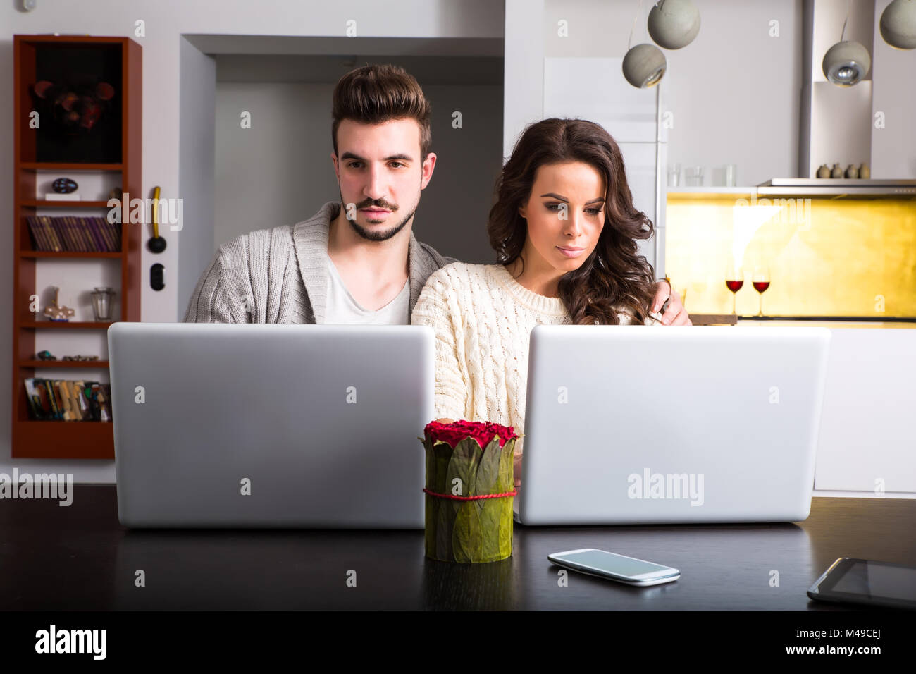 Young couple in front of their Laptop Computers at home Stock Photo - Alamy