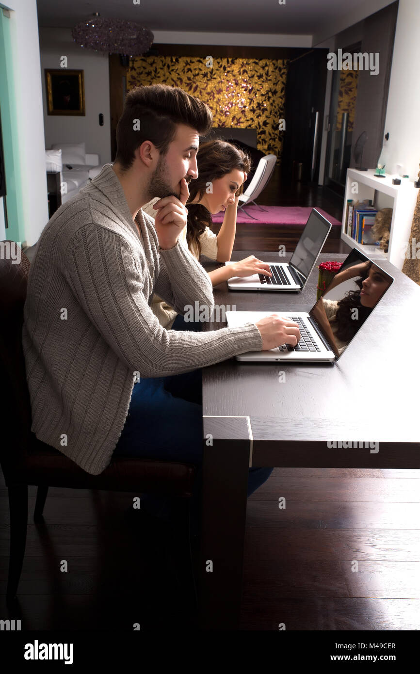Young couple in front of their Laptop Computers at home Stock Photo - Alamy