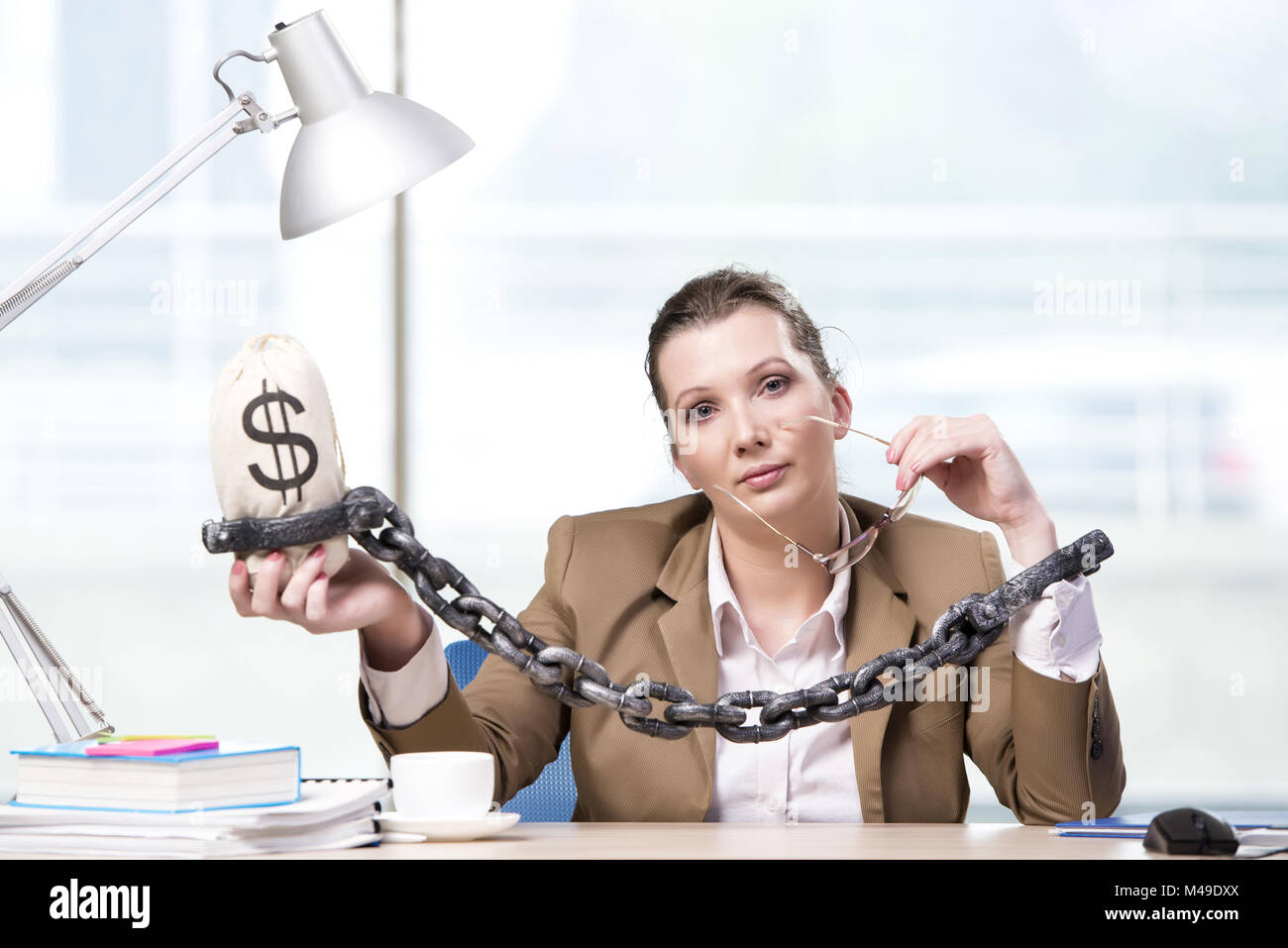 Woman chained to her working desk Stock Photo - Alamy