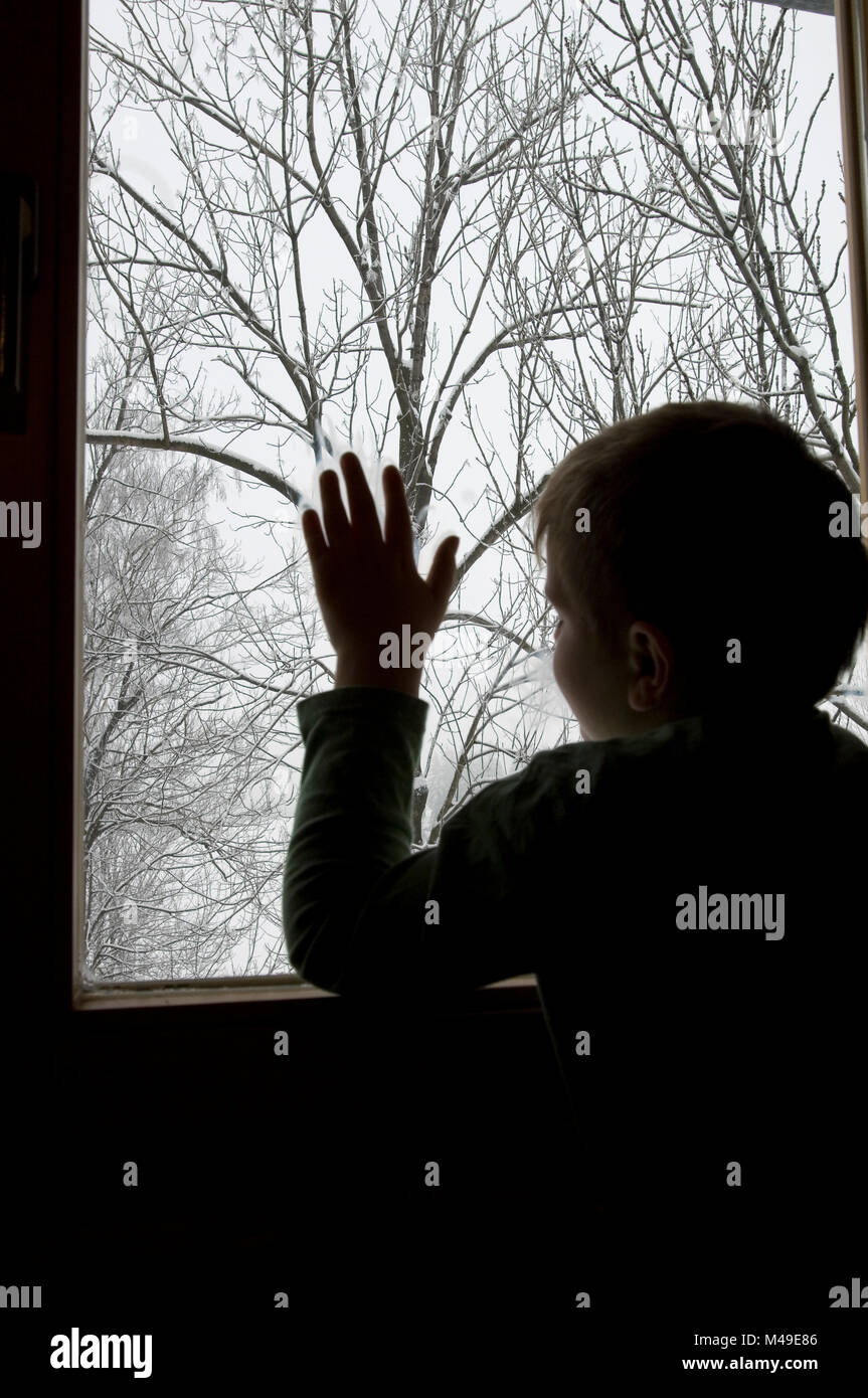 Young boy looking out of window Stock Photo - Alamy