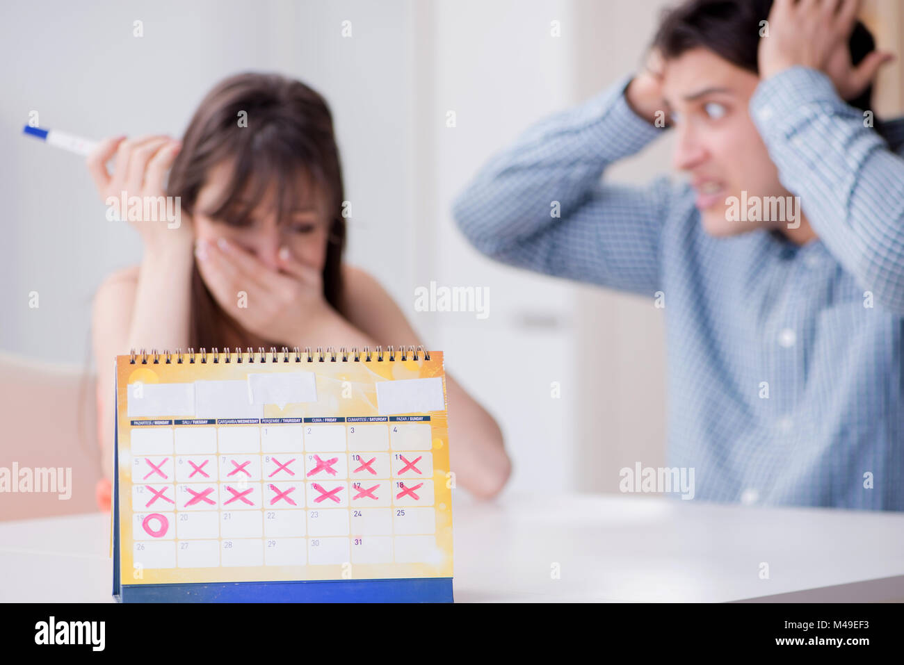 Young family in pregnancy planning concept with ovulation calendar ...