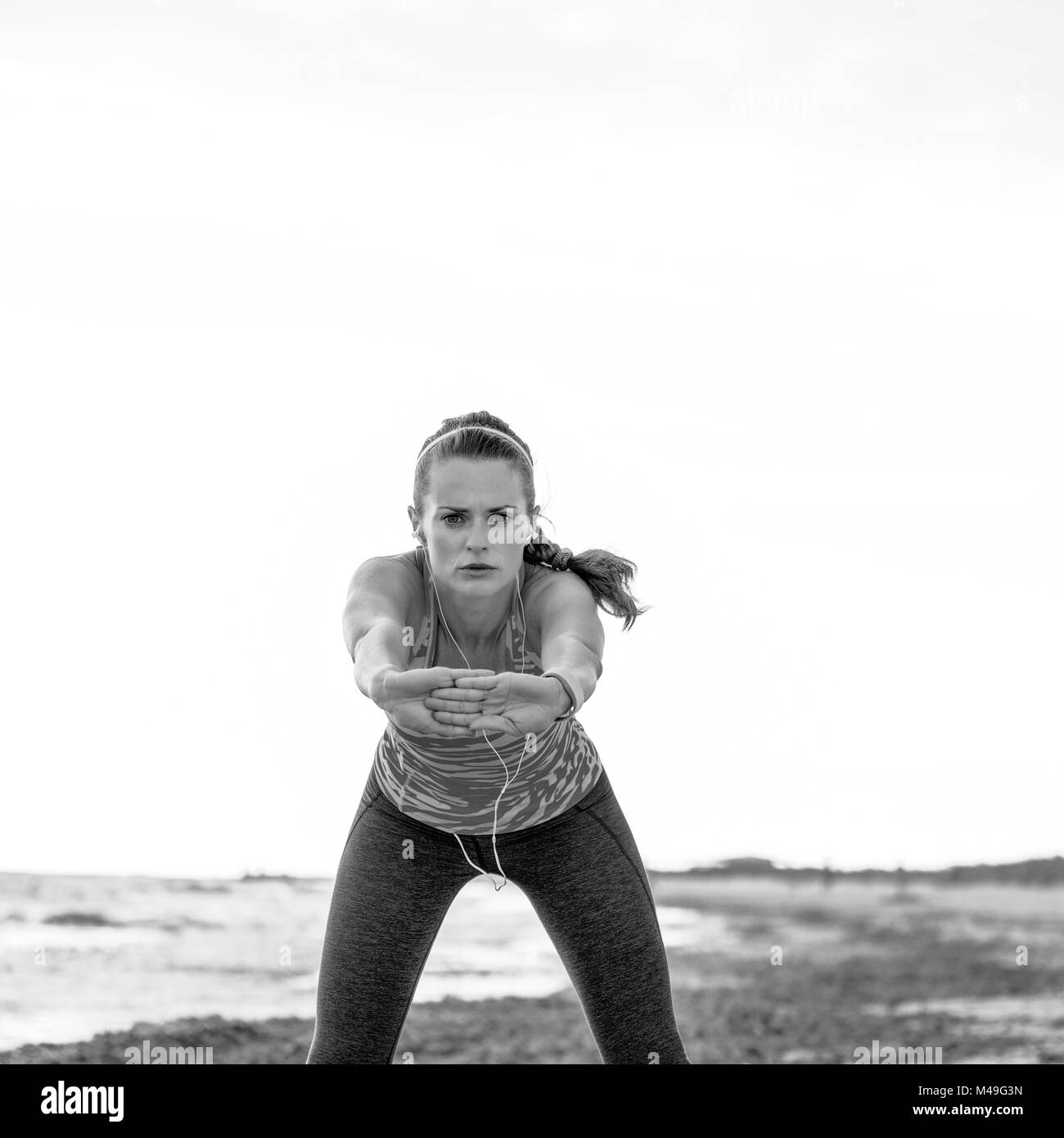Refreshing wild sea side workout. Full length portrait of fit woman in ...