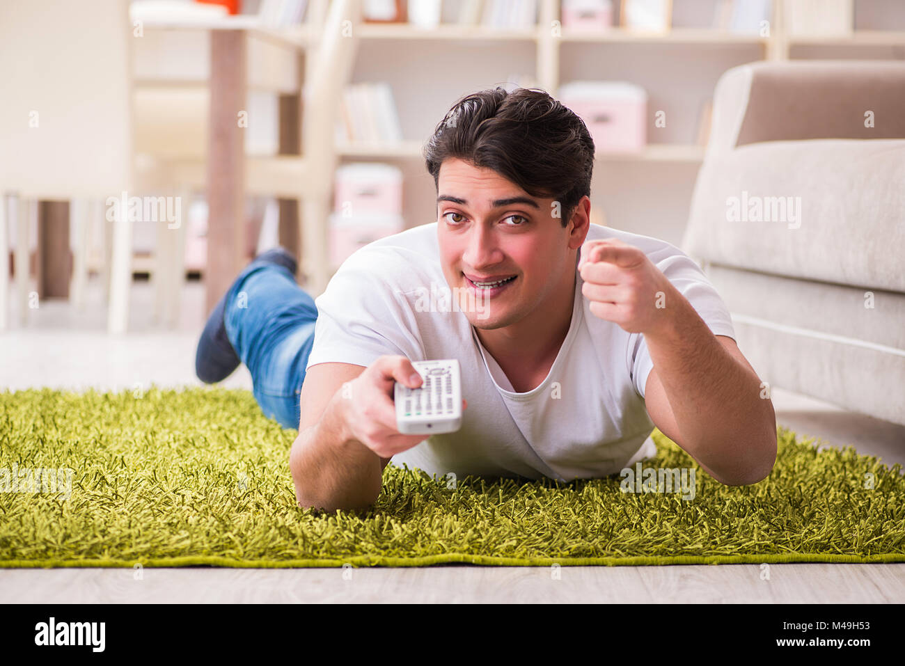 Man watching tv at home on floor Stock Photo - Alamy