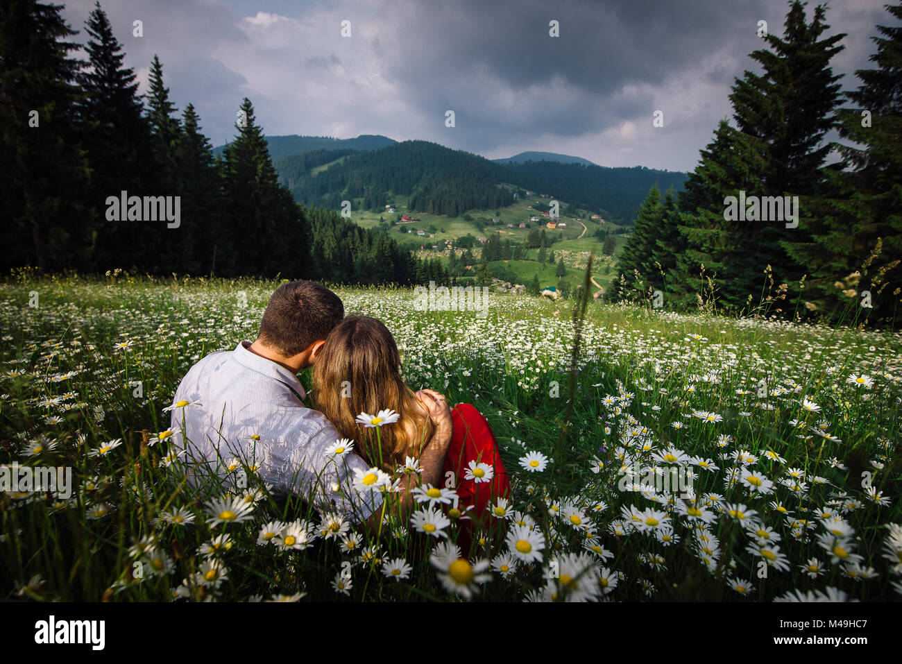 Back view of the peaceful couple in love softly hugging while sitting ...