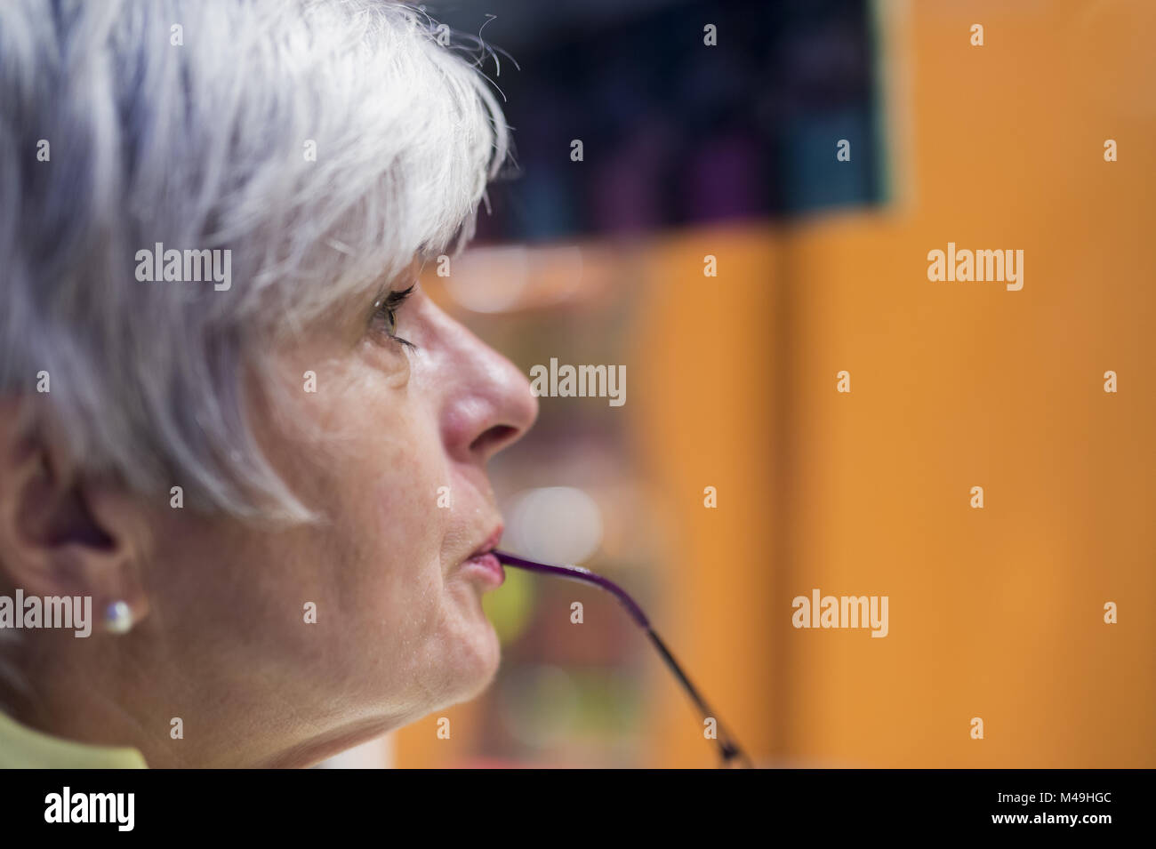 Senior with attentive look and temples in the mouth Stock Photo - Alamy