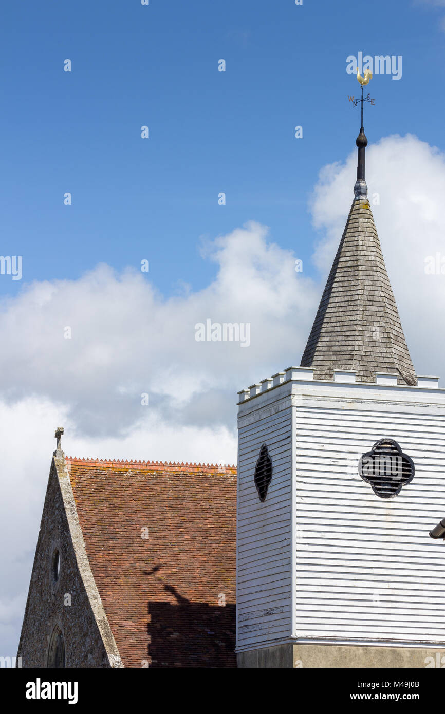 Roof and tower of English country church set against white clouds and ...